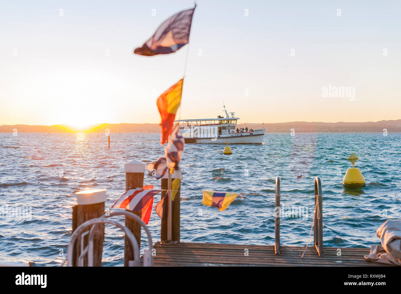 Sunset with red-yellow sun on a lake or sea. Sky, shore, sun and water ...
