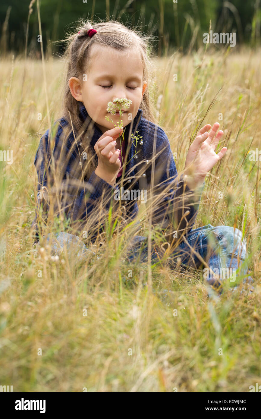 Girl sniffs a flower Stock Photo - Alamy