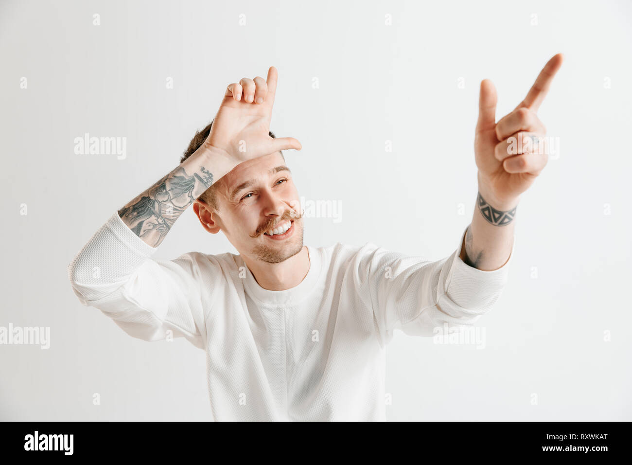 Losers go home. Portrait of happy guy showing loser sign over forehead ...