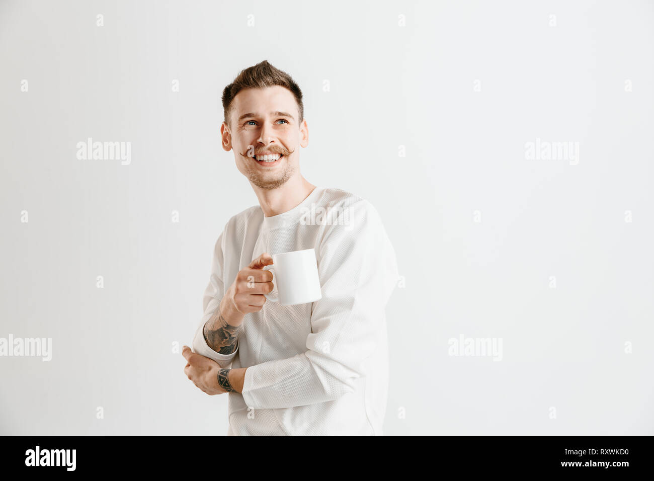 Taking a coffee break. Handsome young man holding coffee cup while ...