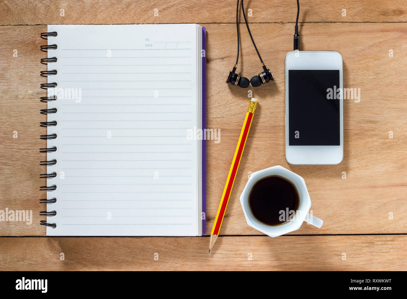 Bank notebook with pencil laying on the brown table. White mobile with ...