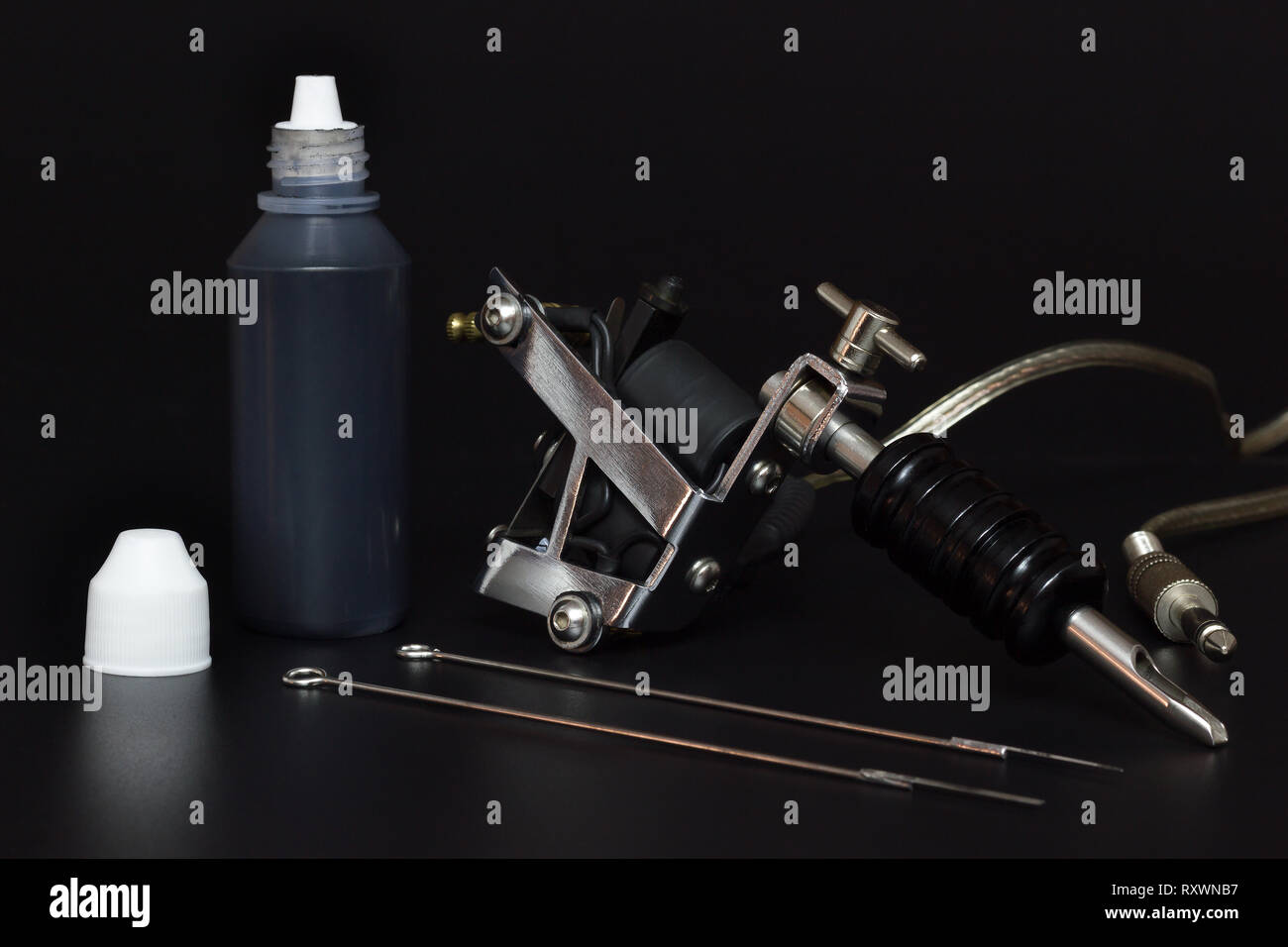Tattoo machines and Bottles tattoo Ink in darkness. Equipment for ...