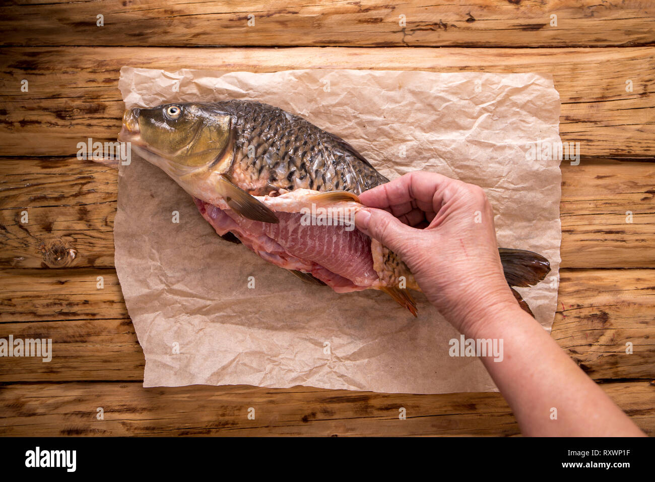 Cook removes carp skin Stock Photo - Alamy