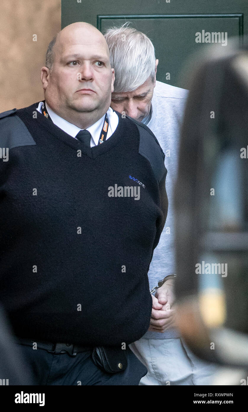Geoffrey Crossland (right) is lead away in handcuffs to a prison van ...