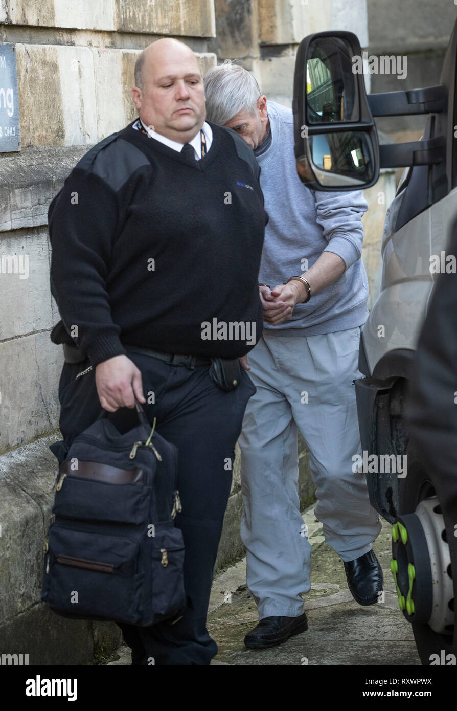 Geoffrey Crossland (right) is lead away in handcuffs to a prison van ...
