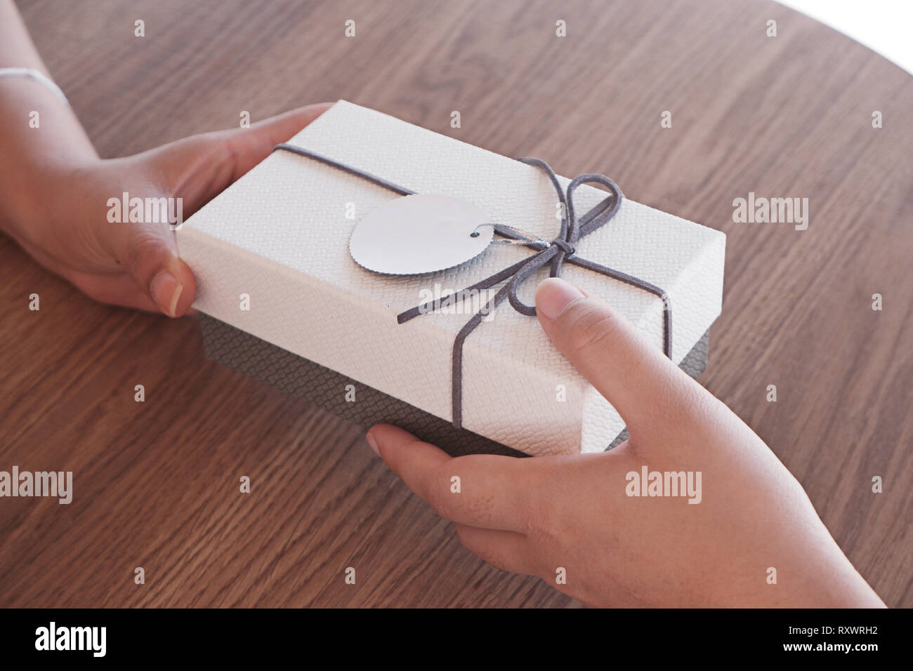 Hands giving and receiving a present Stock Photo - Alamy