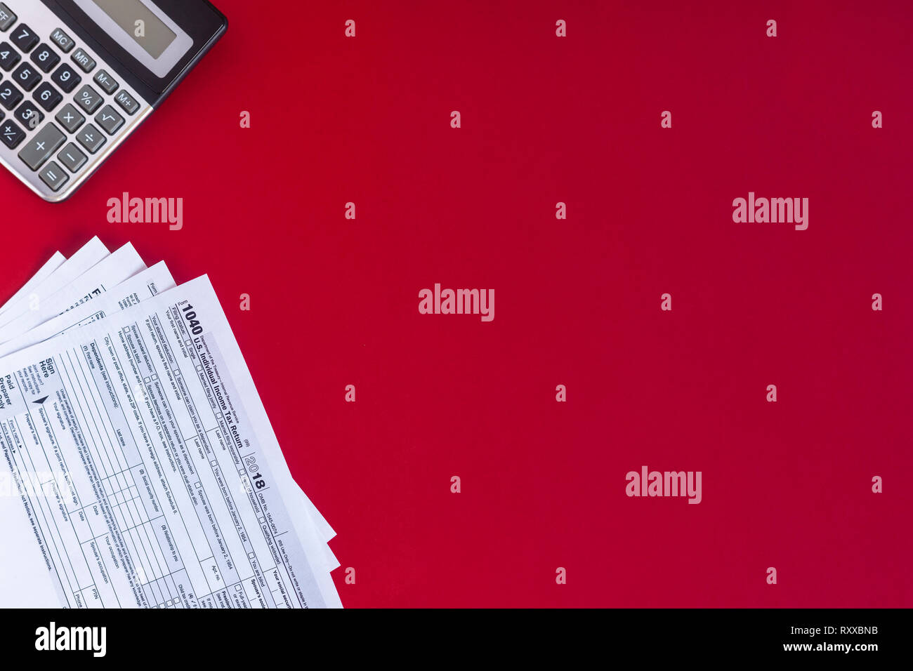 US tax form 1040 with calculator on red background. Copy space Stock ...