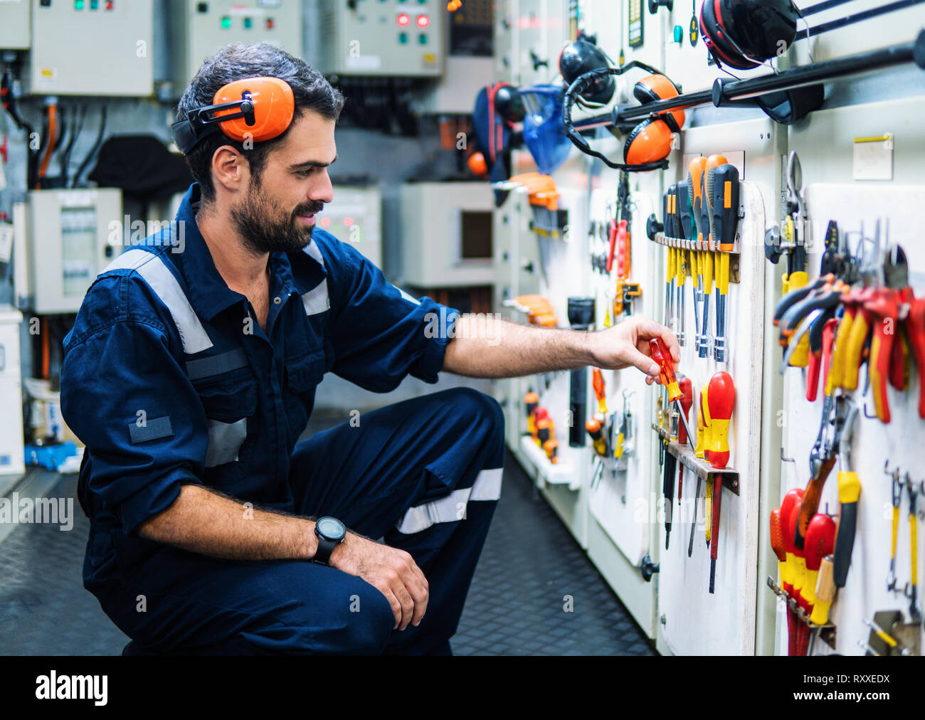 Marine engineer officer working in engine room Stock Photo - Alamy