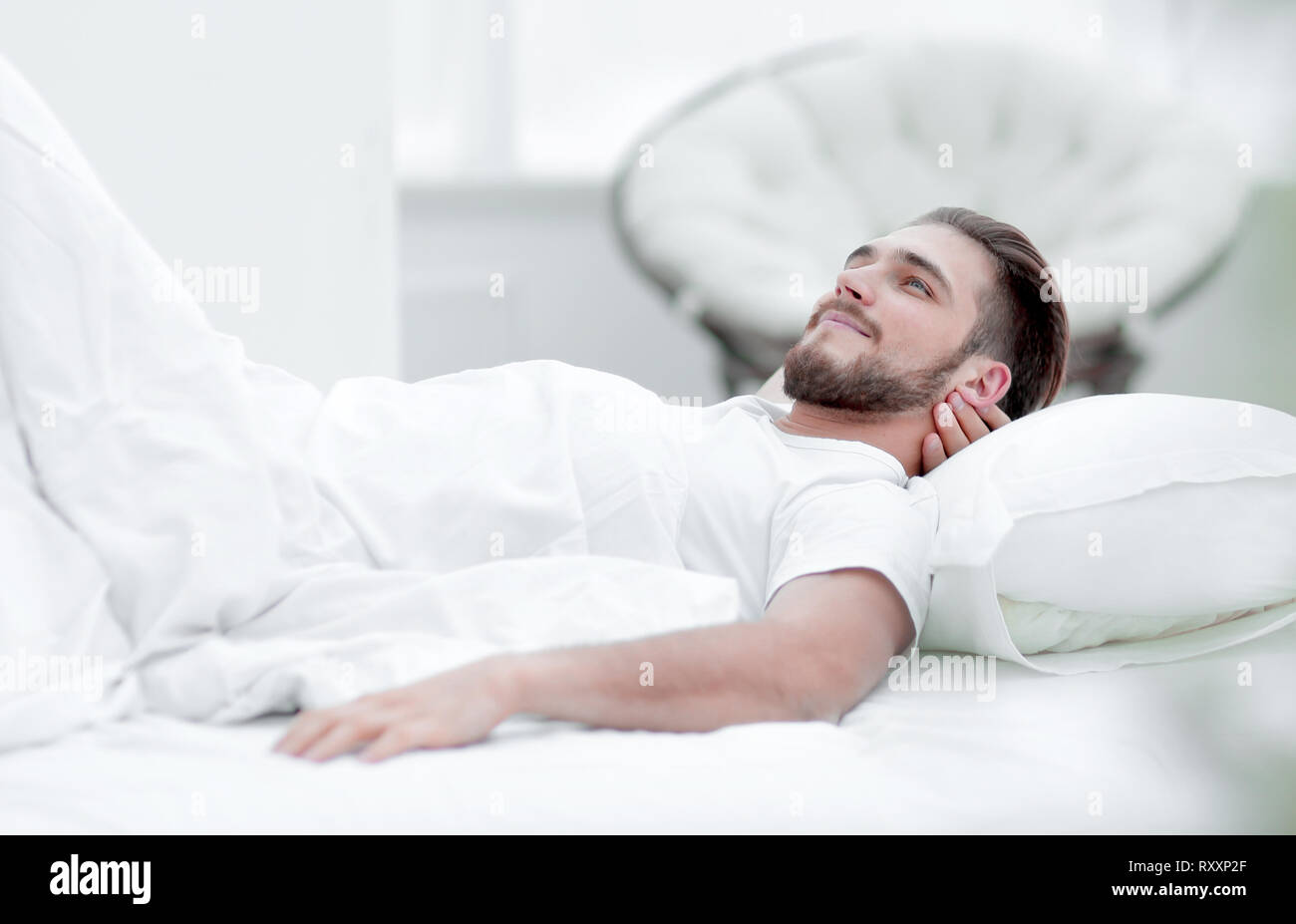 tired man resting on a comfortable bed Stock Photo - Alamy