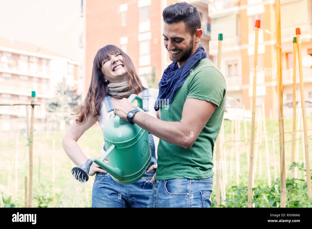 beautiful engaged couple watering plants in the garden Stock Photo - Alamy