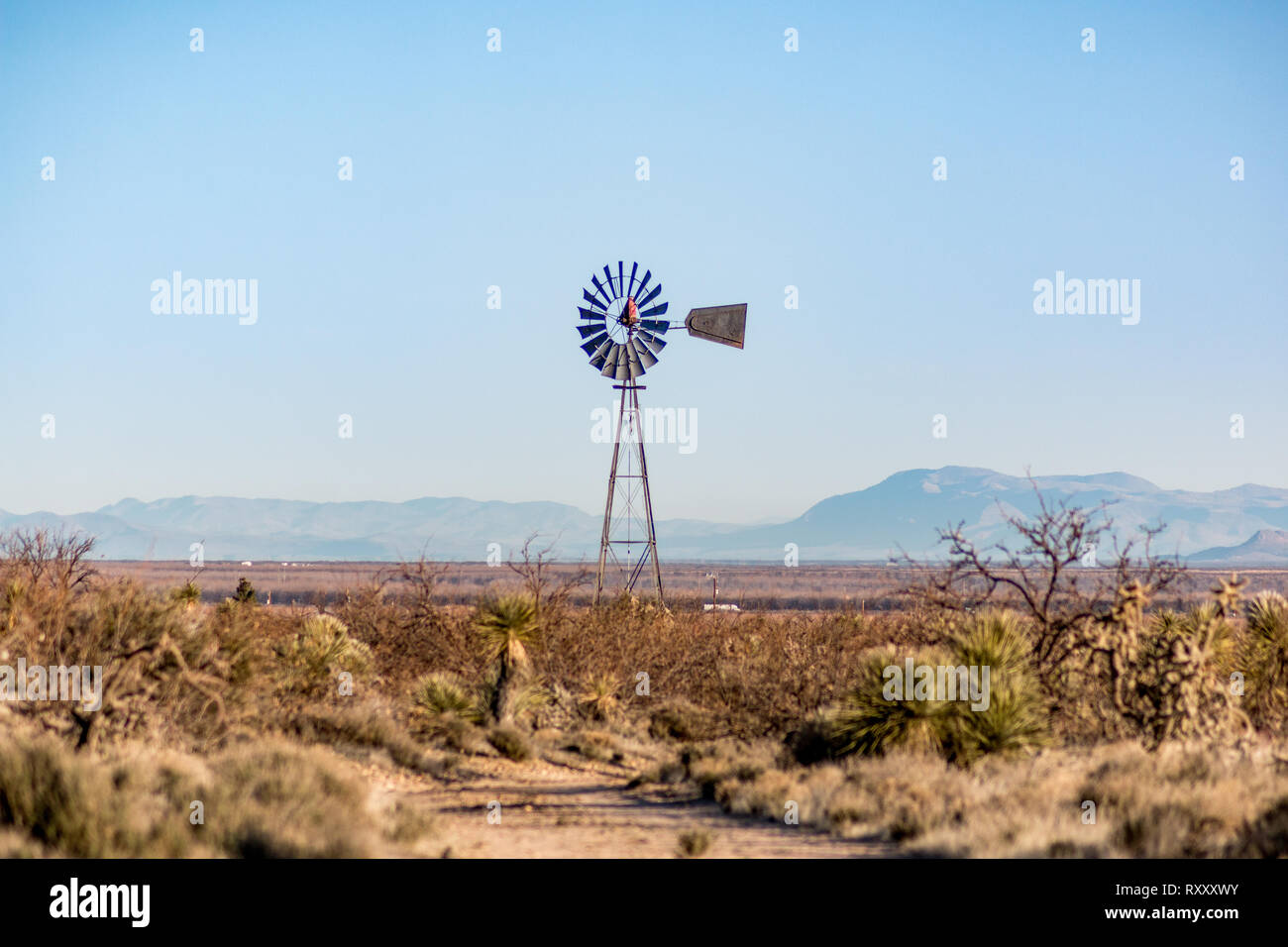 A windmill stands, isolated in the desert landscape of Arizona Stock ...
