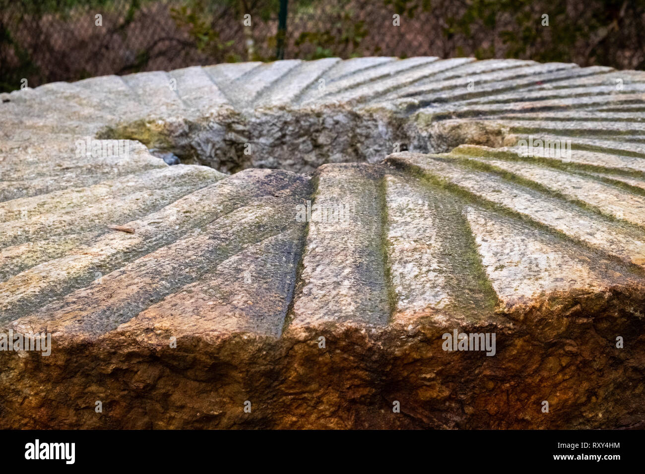 Rough texture of an old grooved millstone used to grind corn or wheat ...