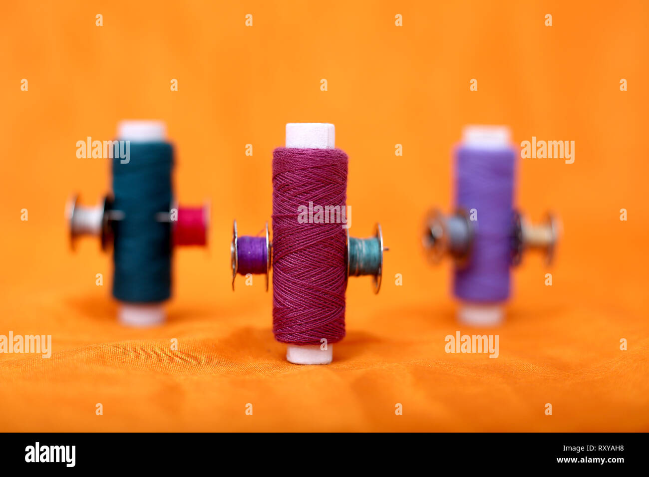 Spool of thread and bobbins. Isolated on the yellow background Stock ...