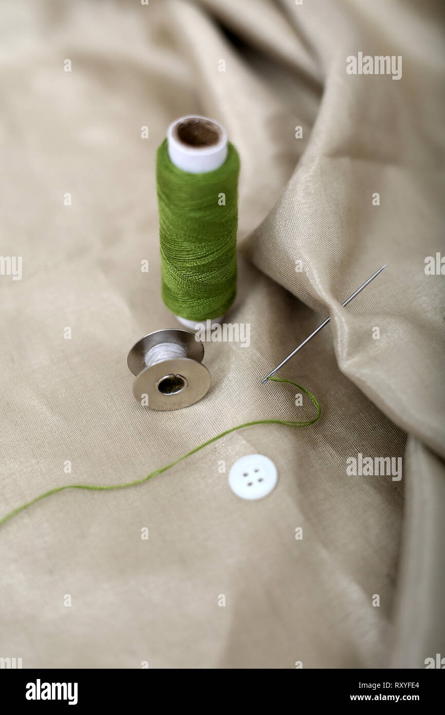Portrait of needle attached in cloth with green Sewing thread and ...