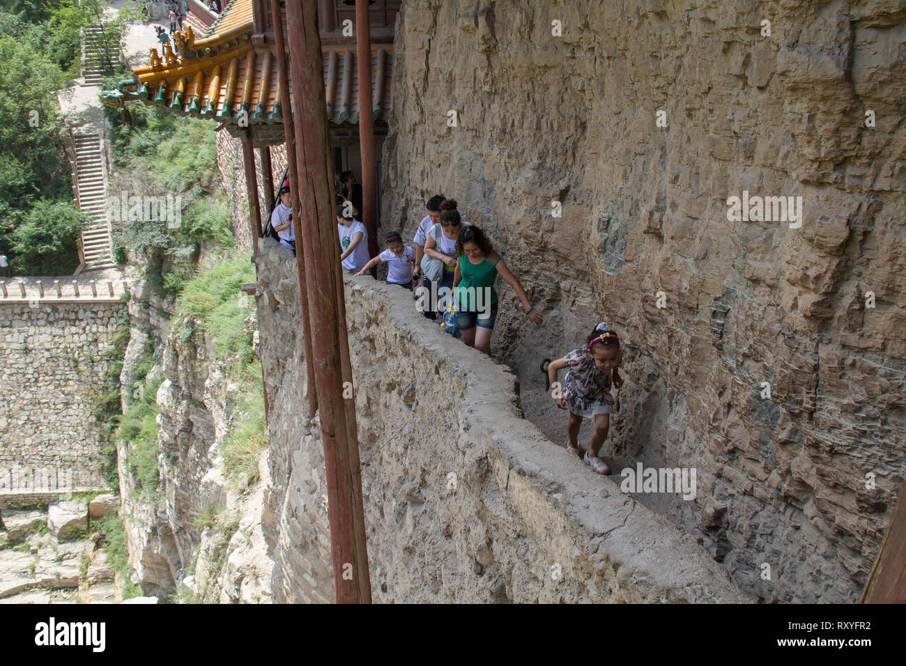 A young Chinese girl sprints up the stone path carved into the cliff at ...