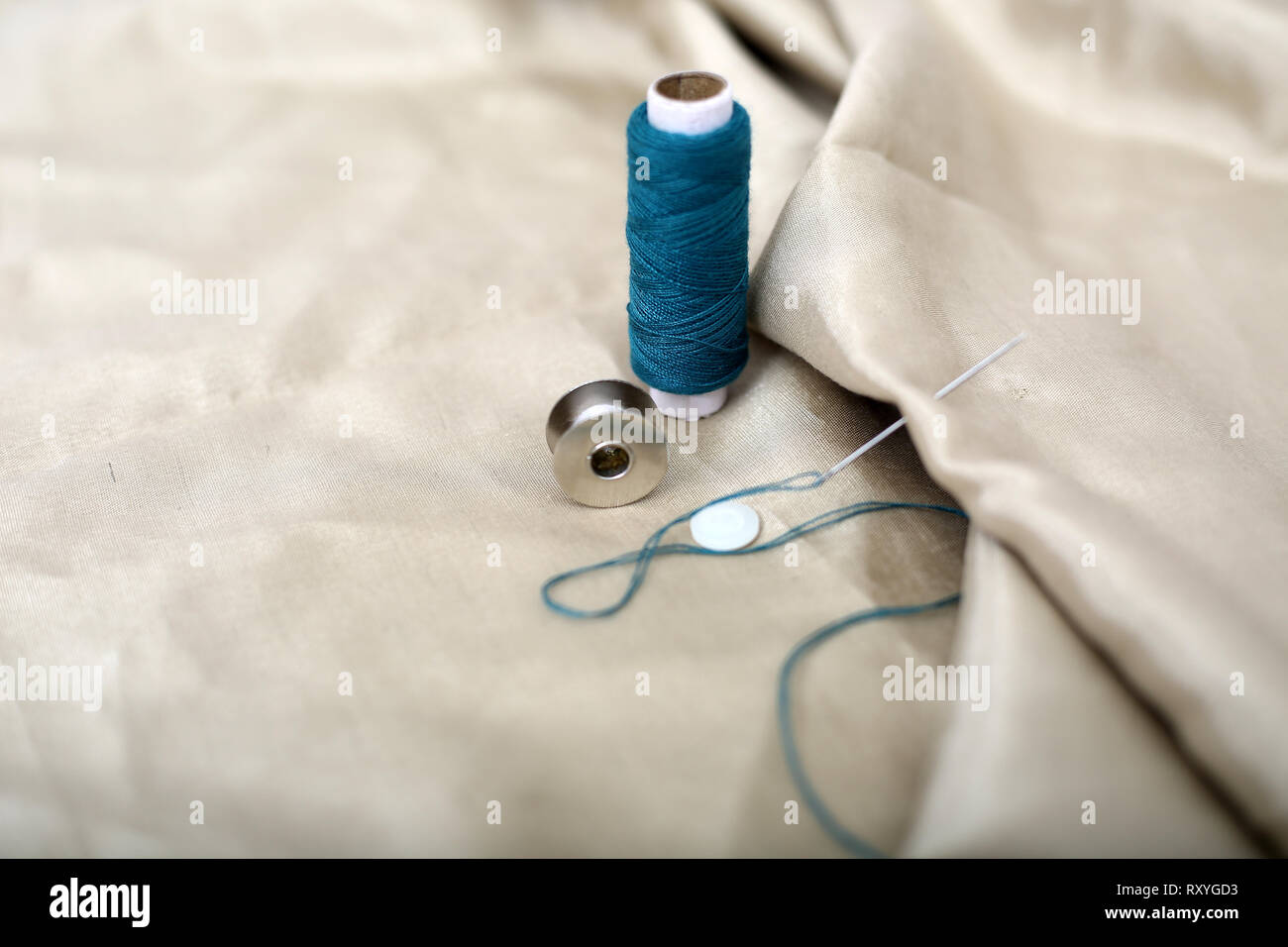 Portrait of needle attached in cloth with Sewing thread and bobbin ...