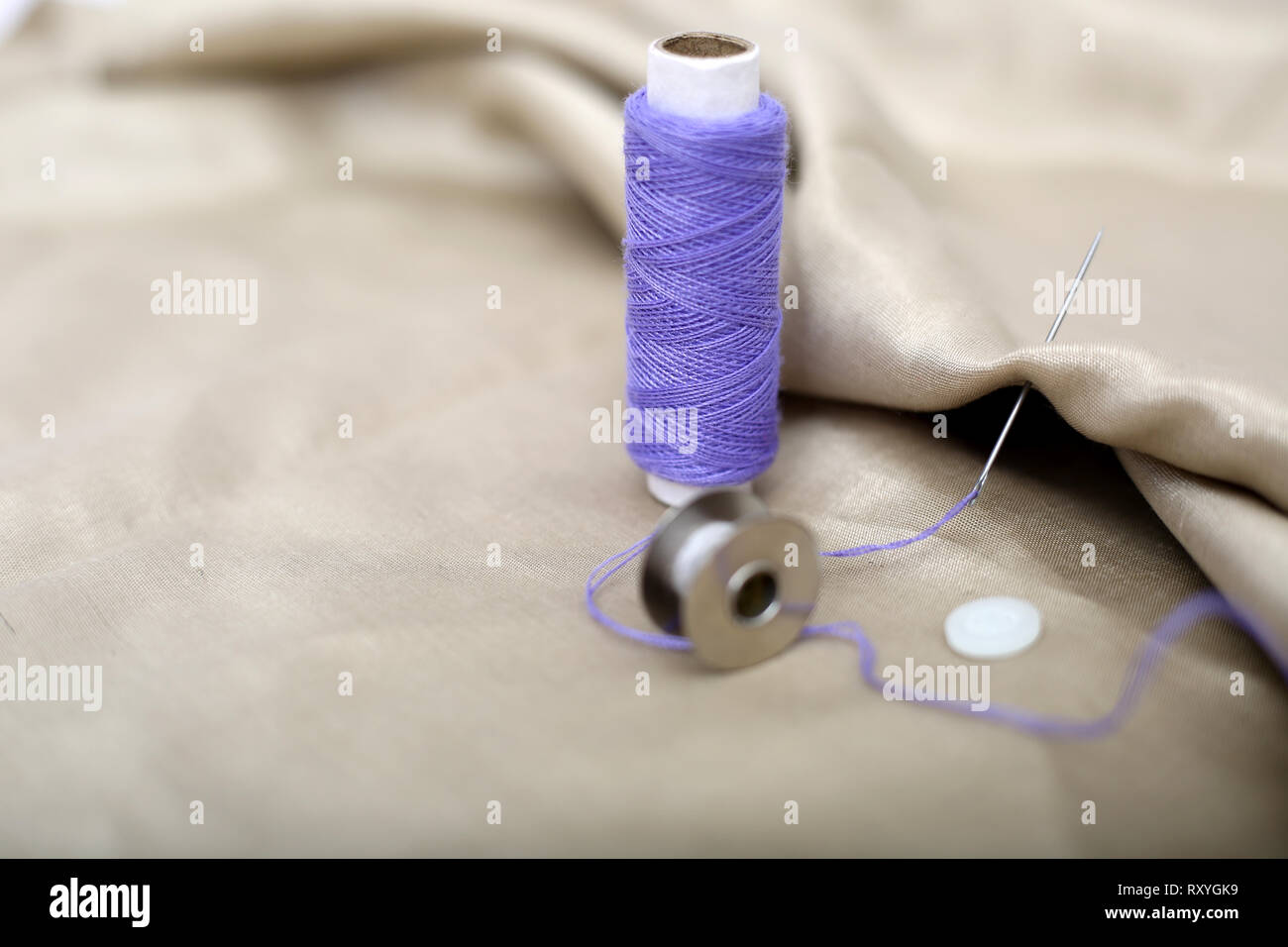 Picture of needle attached in cloth with Purple Sewing thread and ...