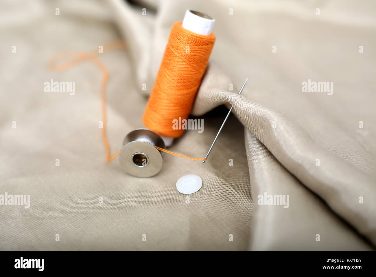 Picture of needle attached in cloth with Orange Sewing thread and ...