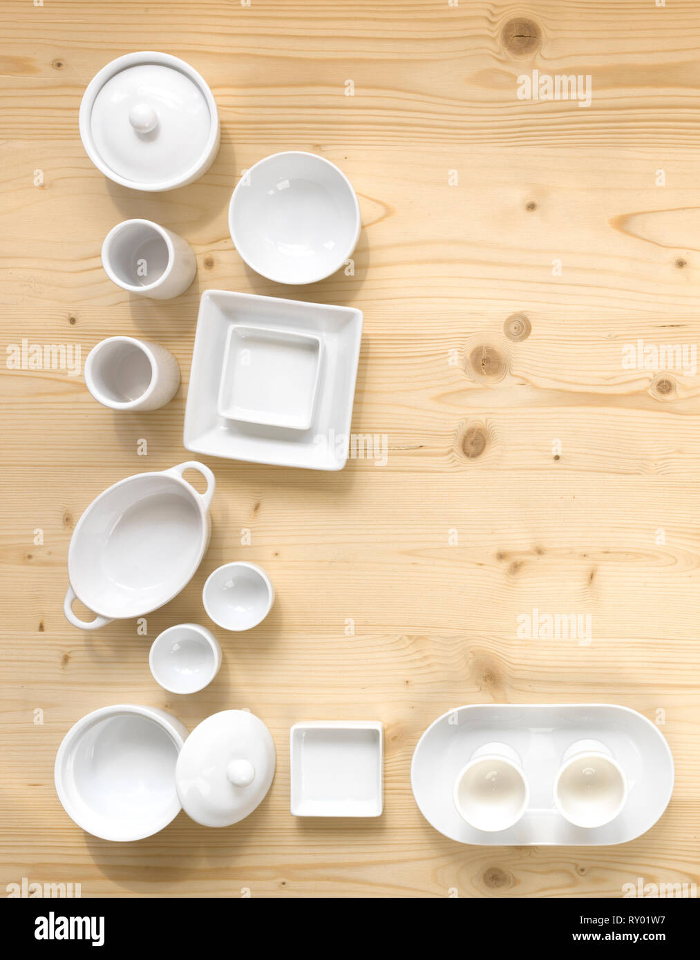 modern, white crockery, in different designs, stands on a light wooden ...