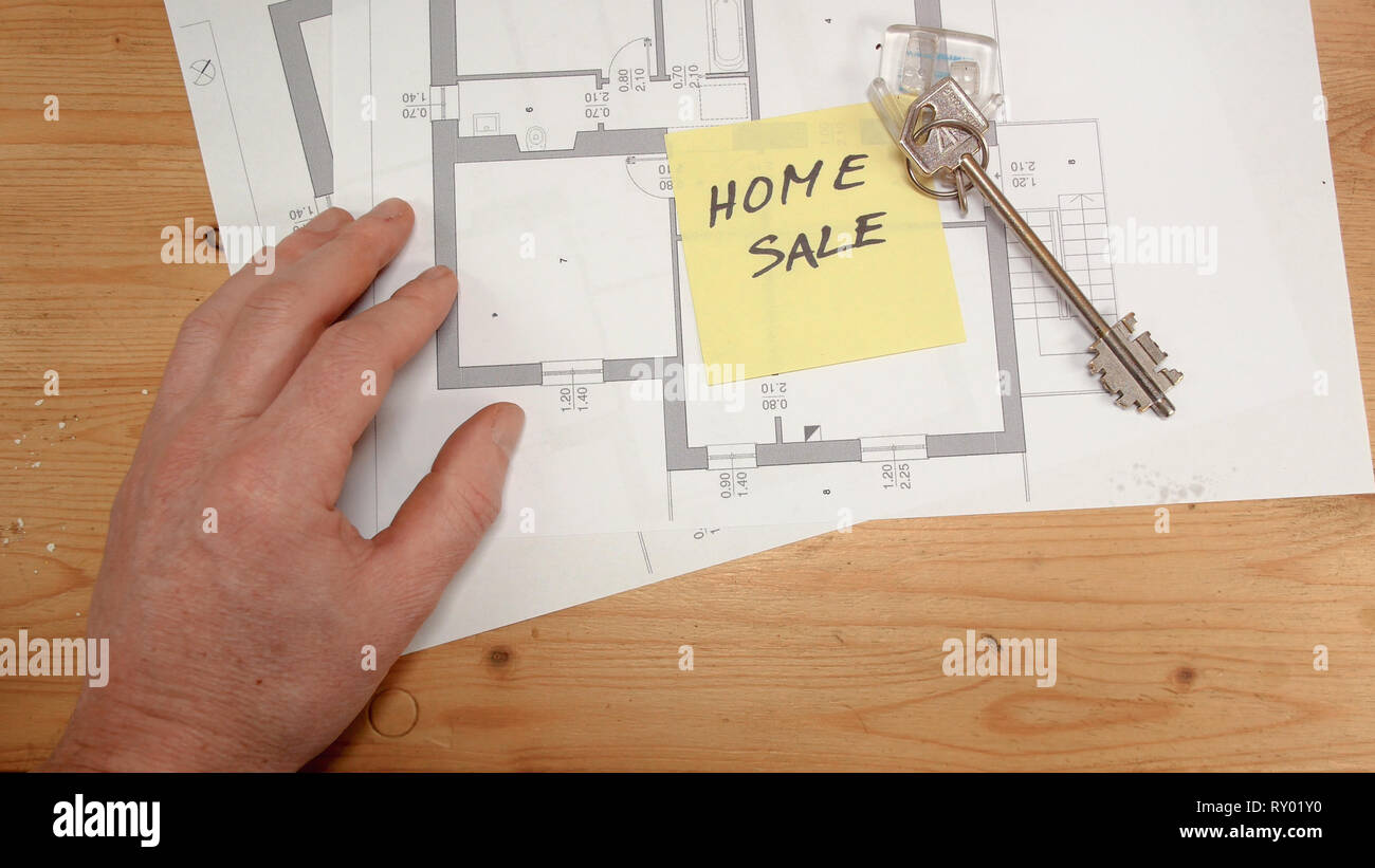 top view, yellow post it with written home sale and key of a house ...