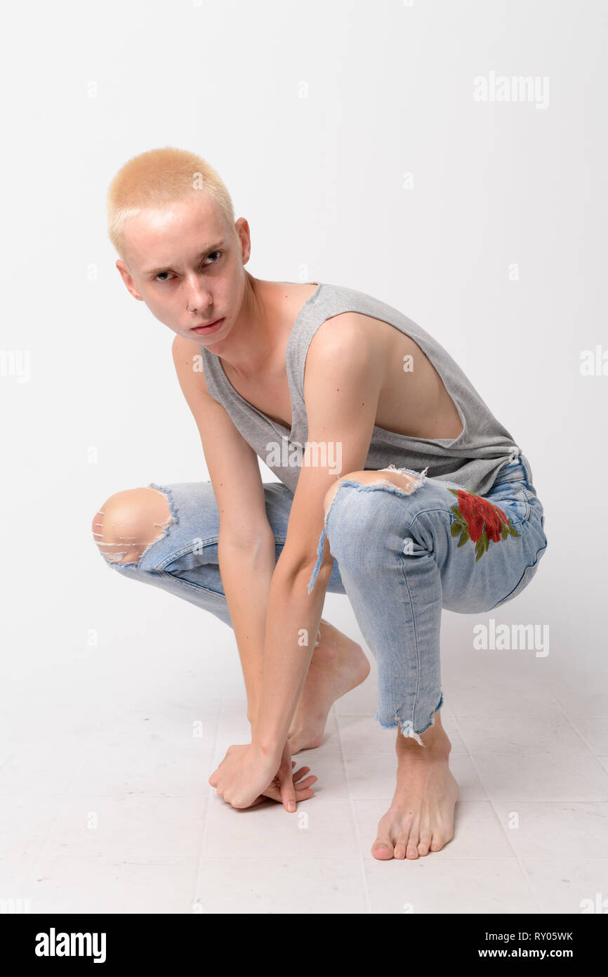 Full body shot of young handsome androgynous man crouching Stock Photo ...