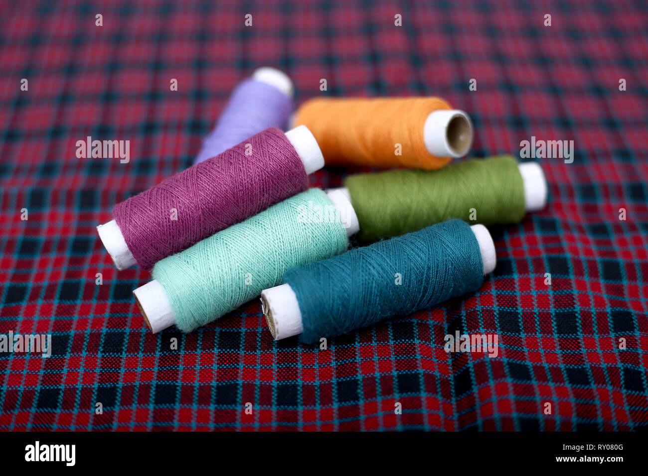 Picture of multi colored sewing thread on the cloth Stock Photo - Alamy