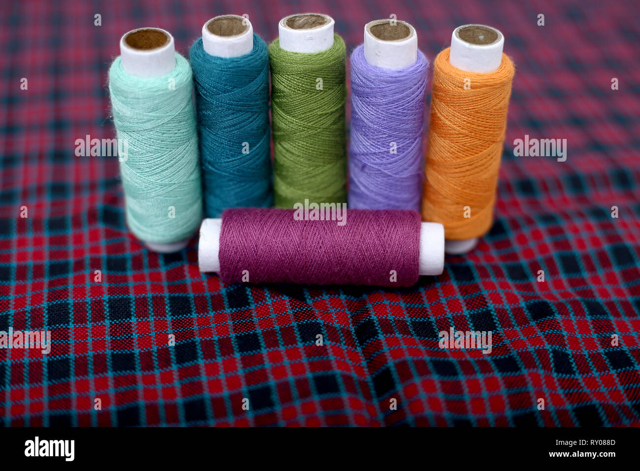 Picture of multi colored sewing thread on the cloth Stock Photo - Alamy