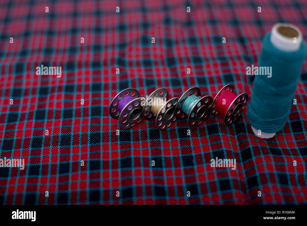 Photo of blue sewing thread and bobbins on the cloth Stock Photo - Alamy