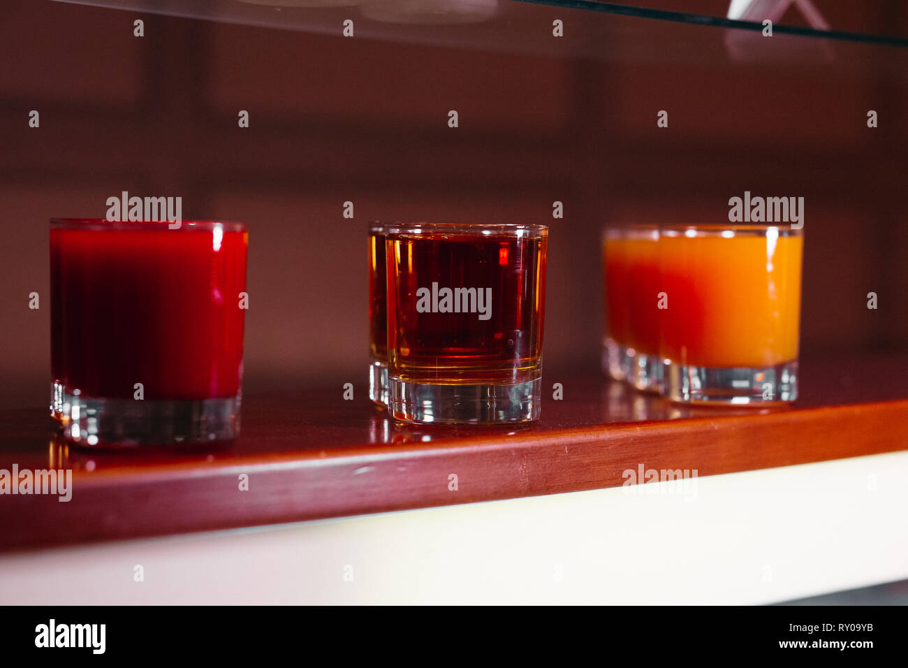 Set of different juice and cocktails on self in bar Stock Photo - Alamy