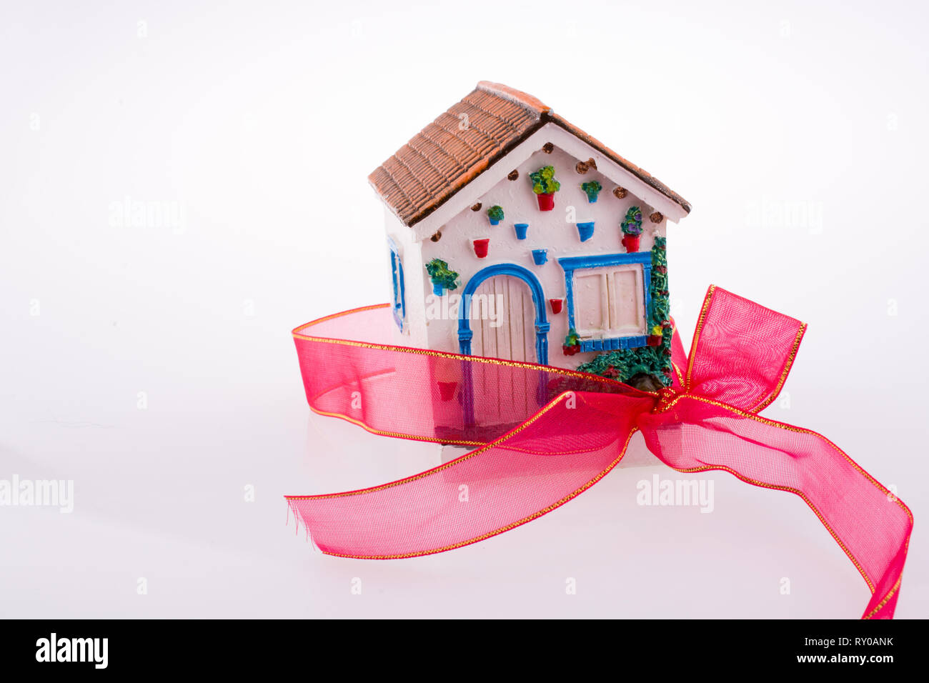 House tied with a red ribbon on a white background Stock Photo - Alamy