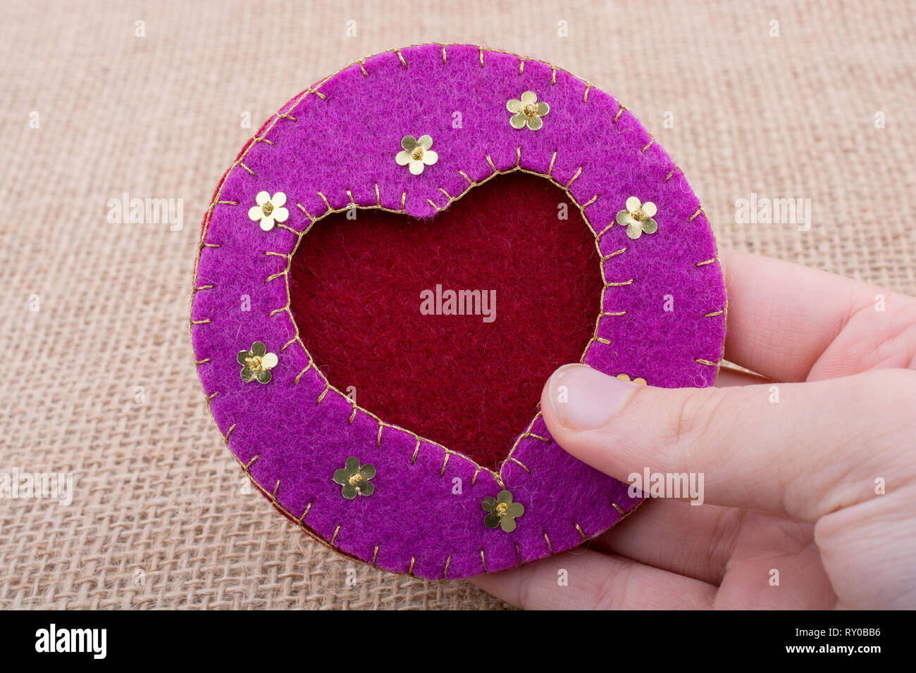 Heart shaped engraved in a mat cloth in hand Stock Photo - Alamy