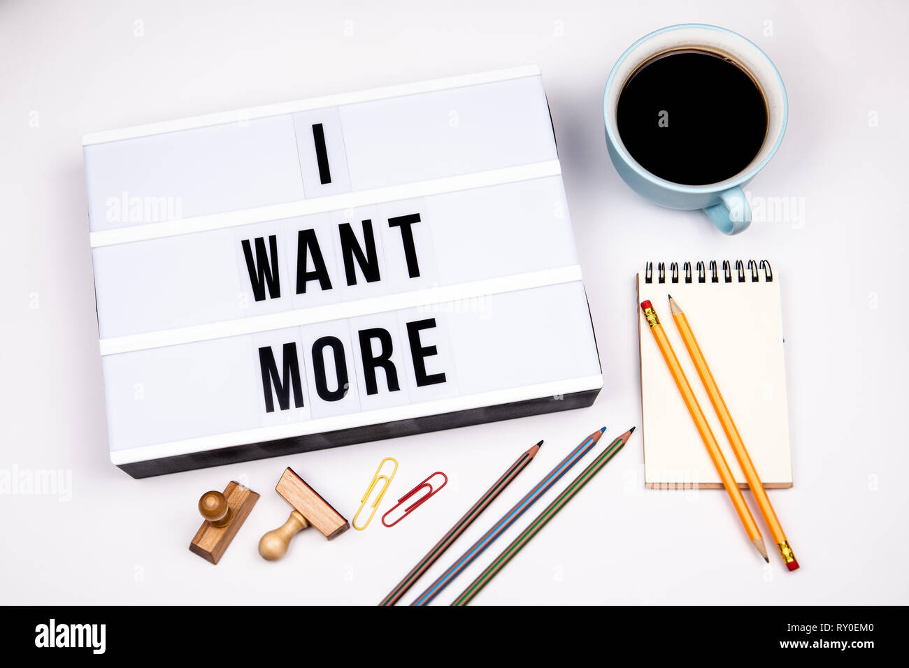 I want more. Text in lightbox. White desk with stationery Stock Photo ...