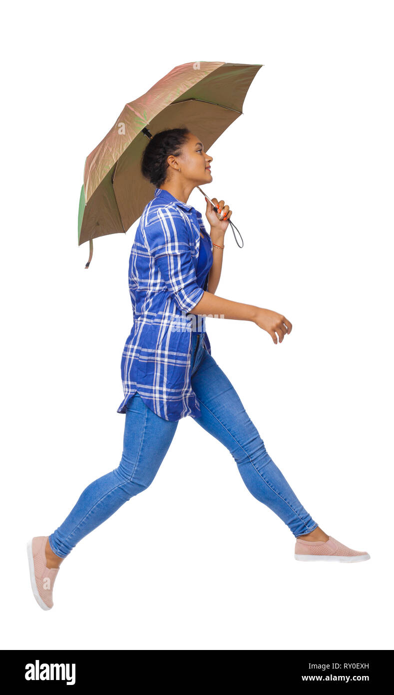 Side view of a woman balancing with an umbrella. girl jumps over a ...
