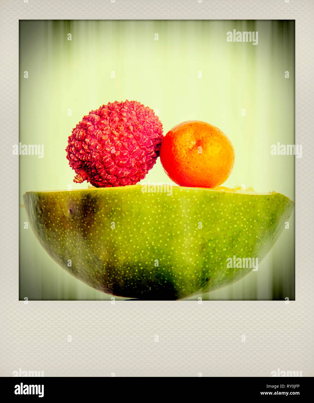 Polaroid photograph of a lychee and mandarin on half a melon Stock ...