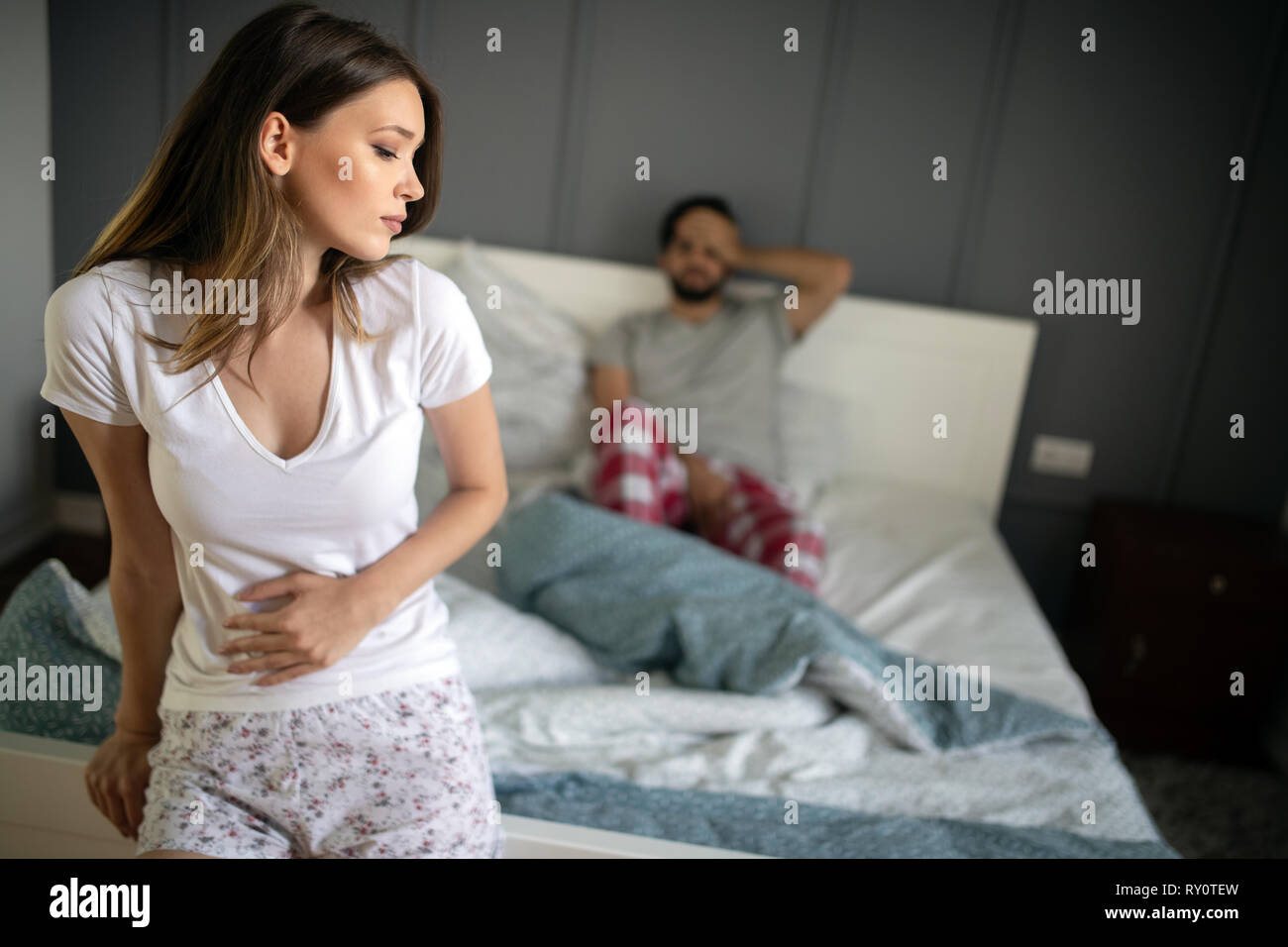 Sad, upset, unhappy woman holding hands on stomach suffering from ...