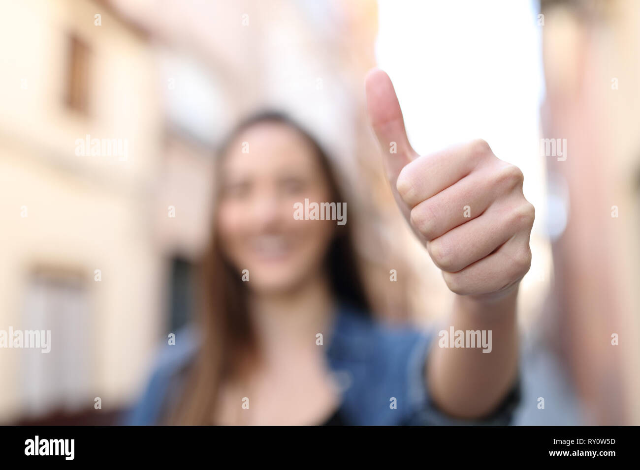 Front view portrait of an unfocussed woman gesturing thumb up in the ...