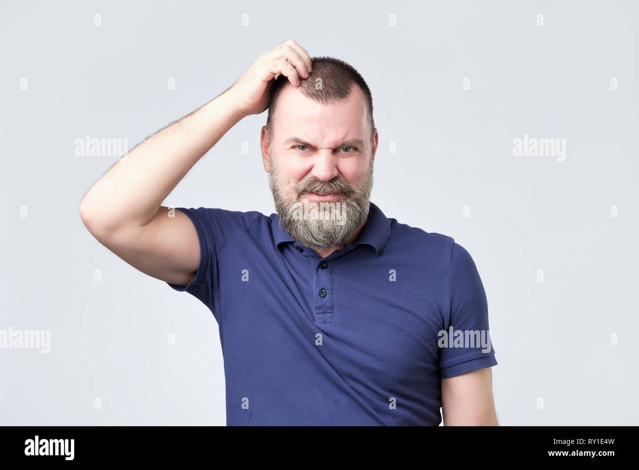 young businessman scratching his head, hard decision, studio shoot ...