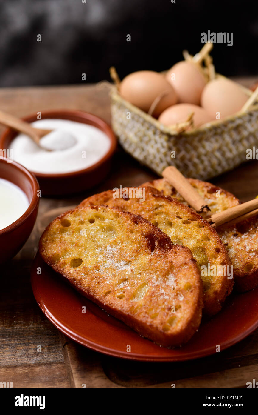 an earthenware plate with some torrijas, typical spanish dessert eaten ...