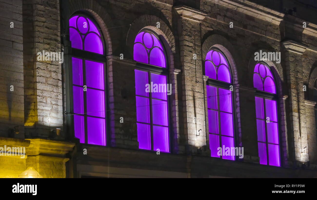 The purple lights inside the building. Seen from the window of an ...