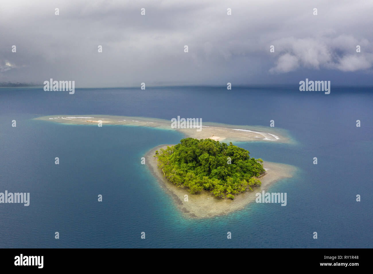 A gorgeous, tropical island is surrounded by reef in Papua New Guinea ...
