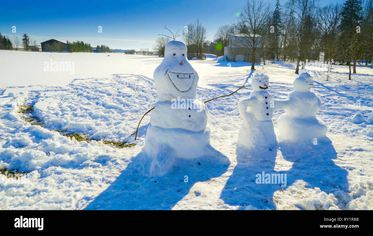 Three white snowman aligned on the ground. There are many snowman ...