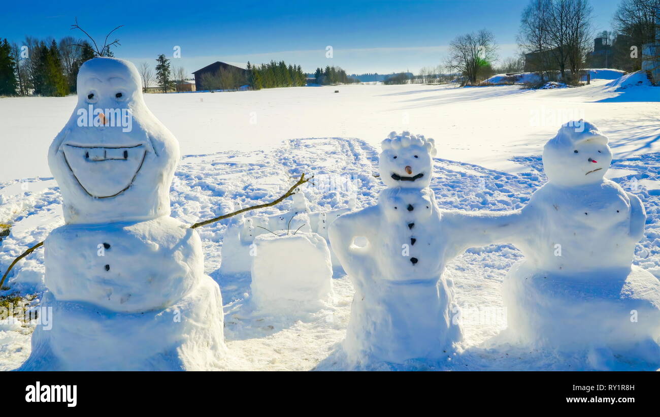 The three snowman in the ground with snow. The snowman holding some ...