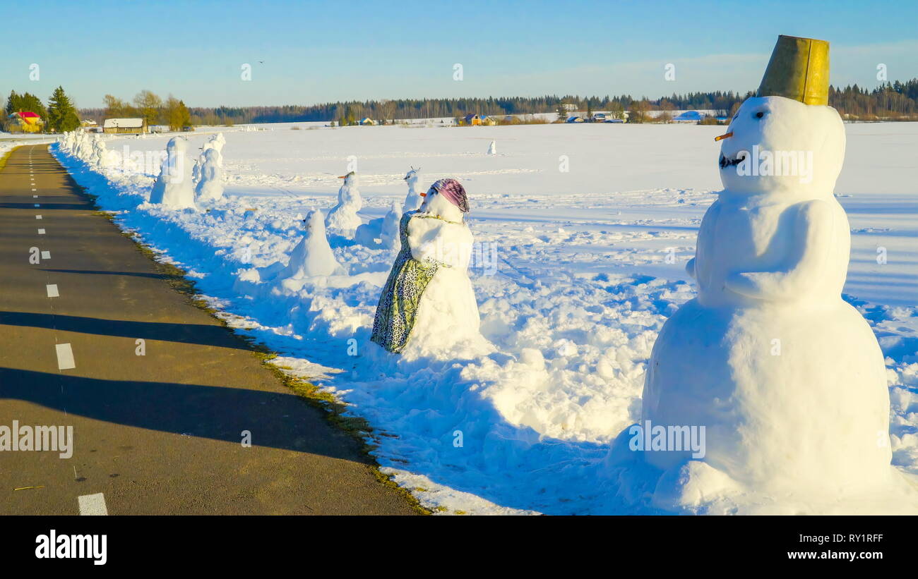 One of the many snowman on the roadside on the big wide field filled ...