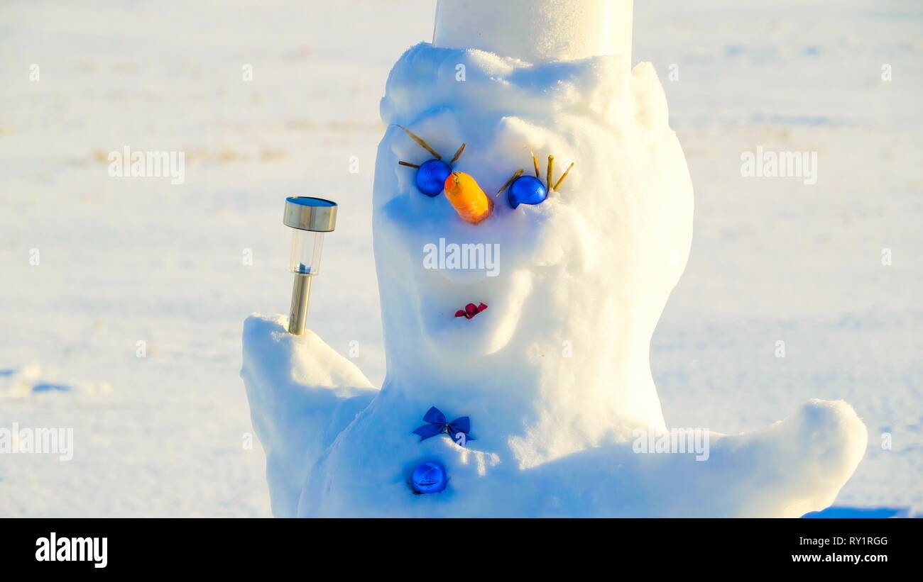 The blue eyed snowman holding a stick. She has lashes on the eyes and ...