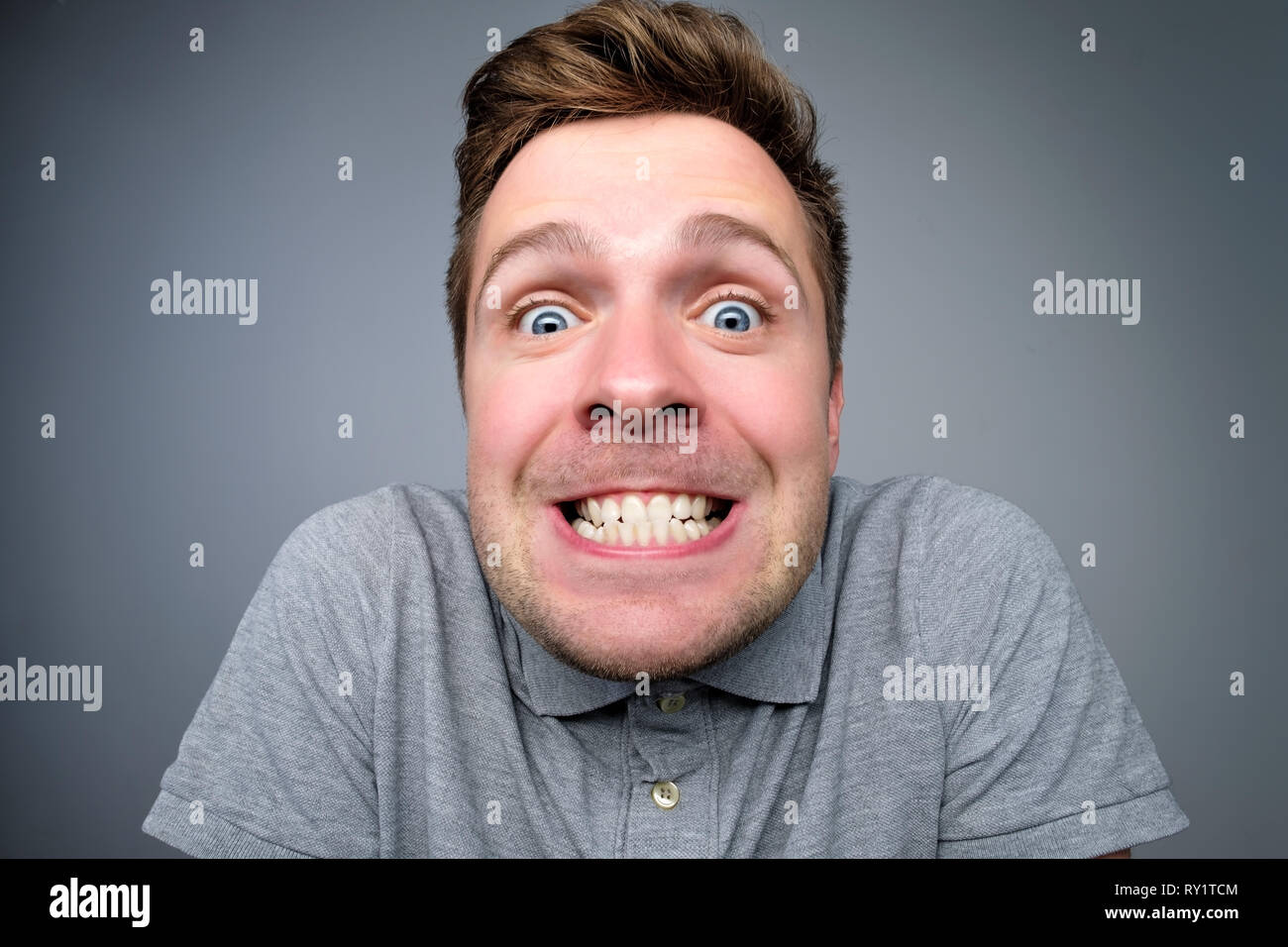 happy european man clenching teeth at camera Stock Photo - Alamy