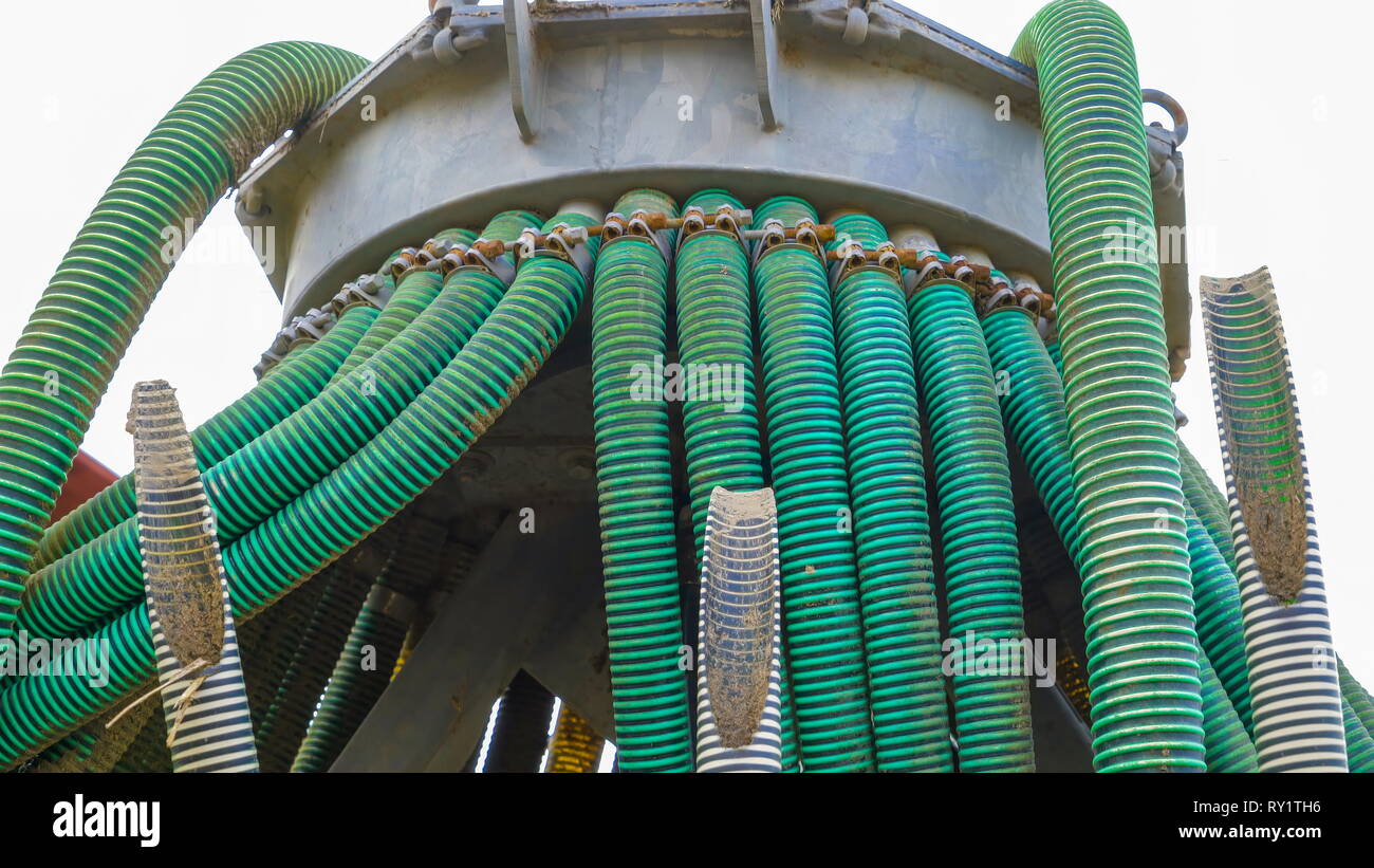 The big green pipes of the vehicle that has mud on it to be used for ...