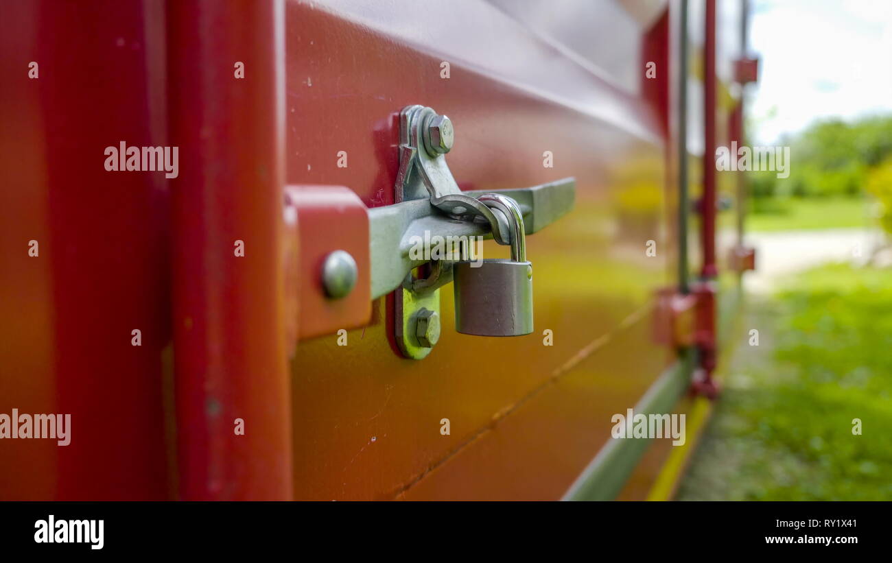 A silver steel padlock on the red truck. The padlock is locked on the ...