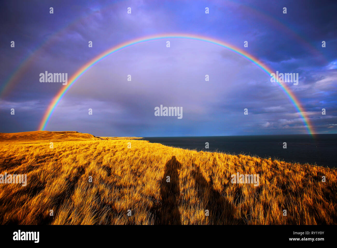 rainbow over field with blue sky and clouds Stock Photo - Alamy
