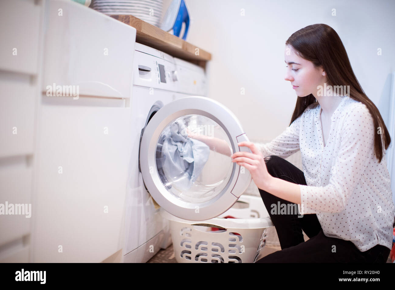 Teenage Girl Helping With Domestic Chores At Home Emptying Washing ...
