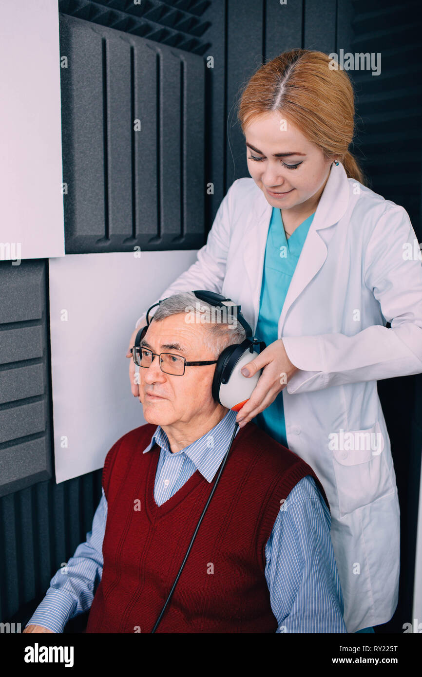 audiologist an auditory examination, for an elderly man using special ...